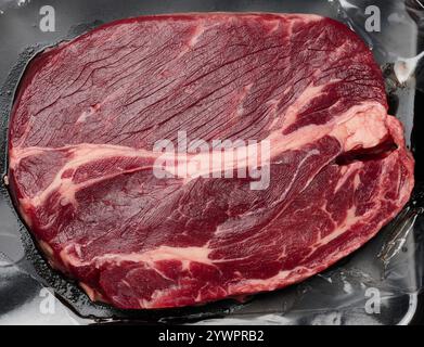 Fresh Raw Chuck eye roll beef steak in a wooden tray with herbs. Dark ...