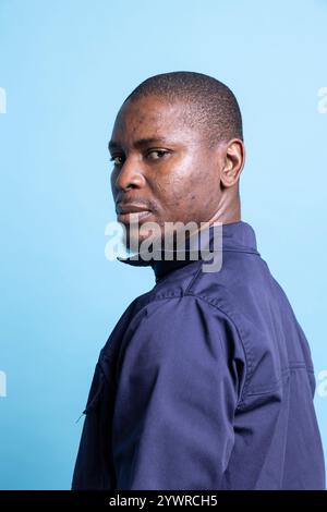 African american bodyguard posing with a baton and uniform in studio ...