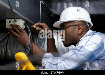 Person performs electrical wiring by connecting green and other wires ...