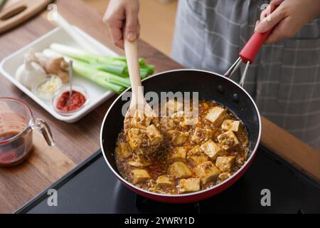Woman stir-frying minced meat, tofu and seasoning Stock Photo - Alamy