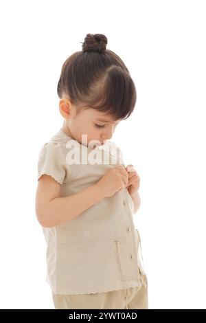 Girl trying her hand at buttoning Stock Photo - Alamy
