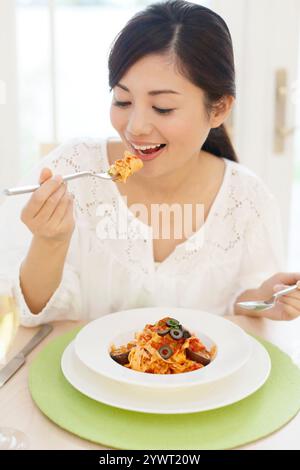 Happy young woman eating pasta in Italian restaurant Stock Photo - Alamy