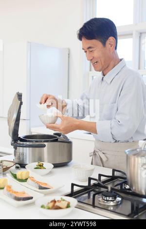 Middle age man eating rice at home happy face smiling with crossed arms ...