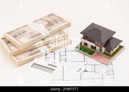 Miniature house and floor plan, wad of notes Stock Photo - Alamy