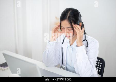Asian women doctor working from home using laptop computer writing ...