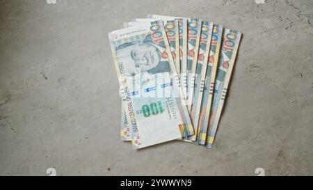 Peruvian banknotes arranged on a concrete surface, displaying various ...