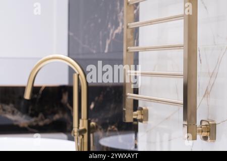 gold-colored heating radiator on a granite wall in the bathroom Stock ...