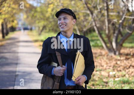 Happy postman with bag and envelopes outdoors Stock Photo - Alamy