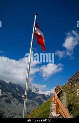 Austrian flag in Grossglockner National Park, snowcapped alps at ...