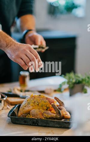 smiling man sprinkling salt on a salad among friends drinking red wine ...