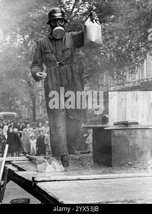 The extinguishing of a fire caused by an incendiary bomb is shown at an ...