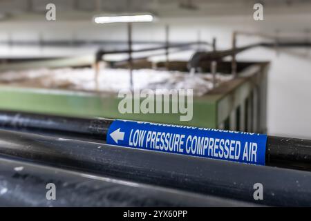 Plastic pipes inside a new small waste water treatment plant labeled ...