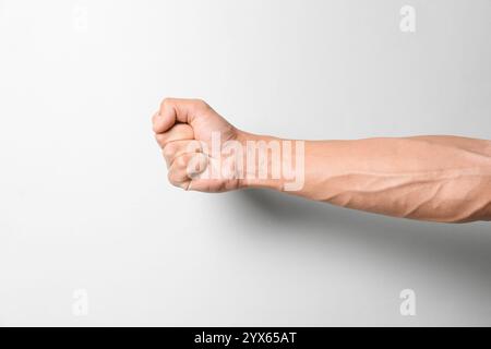 Man with bulging veins on his arm against black background, closeup ...