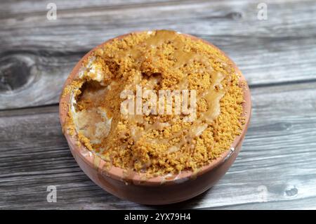 Egyptian bread pudding topped with biscuits butter spread, milk in bowl ...