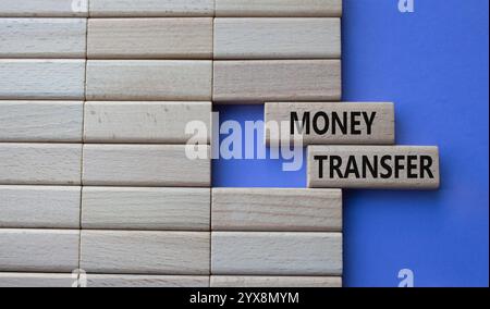 Wooden blocks with symbol of money transfer concept on blue background ...