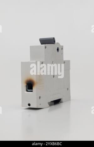 Burned electrical circuit breaker, fuse box on white background. The ...
