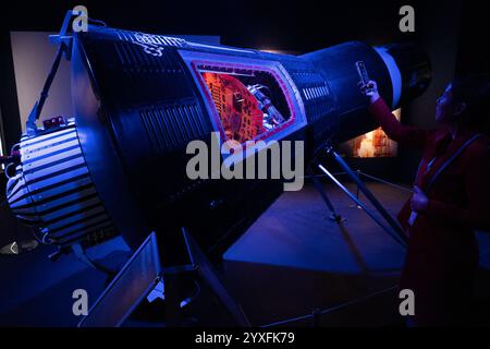 A visitor takes a photo of a Mercury Friendship 7 model on display ...