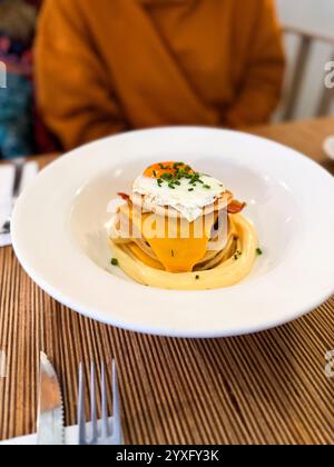 Salty pancake with egg, cheddar cheese sauce and bacon served at ...