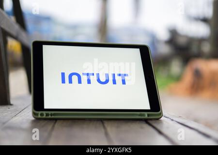 Intuit logo is displayed on smartphone. Intuit Inc. is an American ...