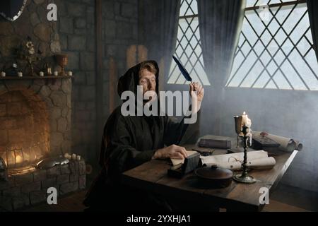 Medieval monk writing historic manuscripts at table Stock Photo - Alamy
