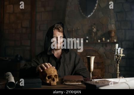 Mystical spooky medieval monk in black cassock with human skull on ...