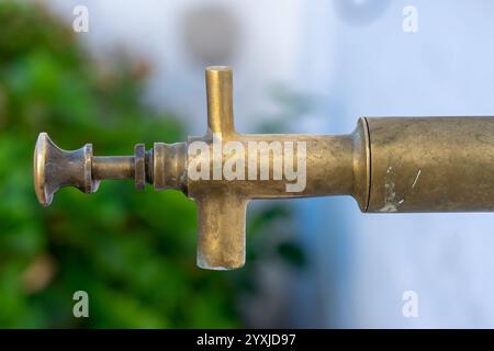 Outdoor push-button tap made of yellow brass Stock Photo - Alamy