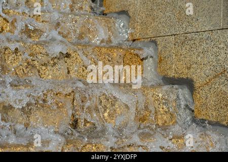 water running down stairs and forming foam passing through stone steps ...