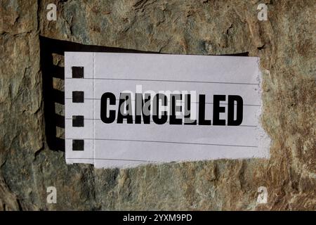 Cancelled message written on ripped torn paper piece with purple ...