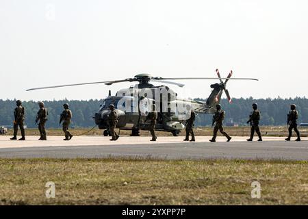 Infantrymen of the German Army prepare to board a NH-90 transport ...