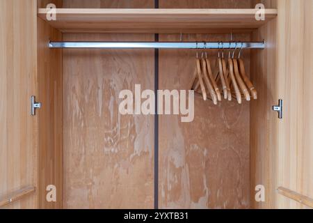 clothes hangers on rail in empty wardrobe Stock Photo - Alamy