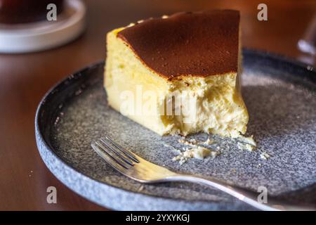 Smooth creamy cheesecake in white fluted dish with fresh mint sprig ...