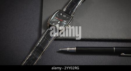 Black pen, wristwatch, notepad on the black background Stock Photo - Alamy