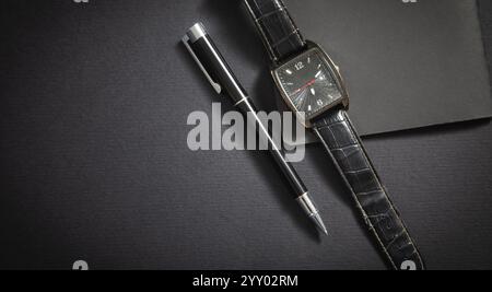Black pen, wristwatch, notepad on the black background Stock Photo - Alamy