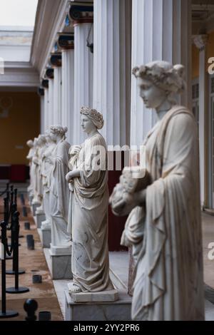 Antique statues of Women in Wreaths. The white stone statues stand in a ...