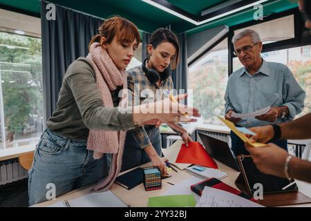 College students collaborating with guidance from elderly professor ...