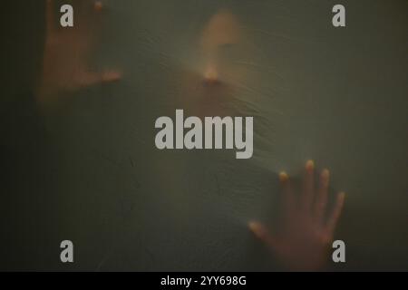 Head and handprint of woman as she suffocates behind fabric, raised ...