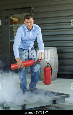 male professional checking a fire extinguisher using clipboard Stock ...