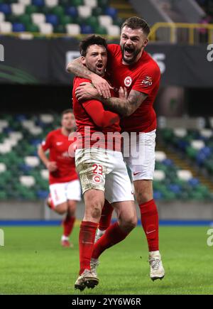 Larne's Tomas Cosgrove (left) celebrates scoring their side's first ...