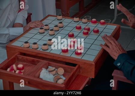 Traditional Qatari men playing Dama board game in Katara beach close up ...