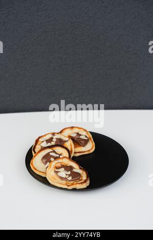 Plate of pancakes dripping with Nutella and almond crumbs with dark ...