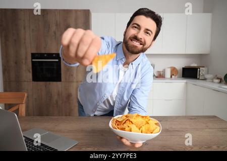 Man eating tasty nachos in kitchen Stock Photo - Alamy