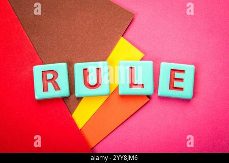 RULE. Alphabet letter tiles on a red textured background Stock Photo ...