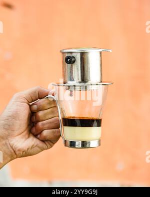 Vertical shot of a glass of cappuccino on a wooden table at a cafe in ...
