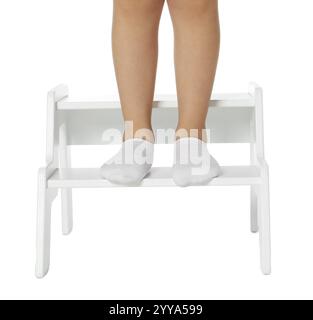 Little girl standing on step stool against white background Stock Photo ...