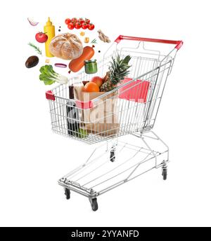 Groceries falling into shopping cart on white background Stock Photo ...