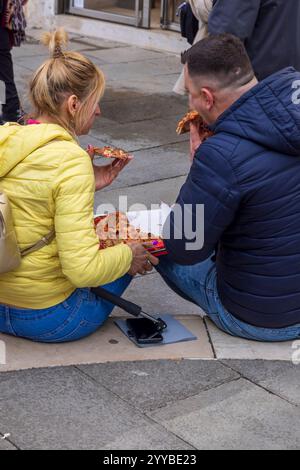Man sitting on curb eating ice cream cone. Rue de la Commune. Montreal ...