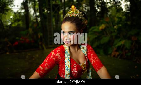 a traditional Sundanese dancer wearing a red costume which is the ...