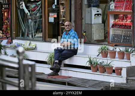 A Nepali man waits outside his shop for tourists to buy goods in Thamel ...