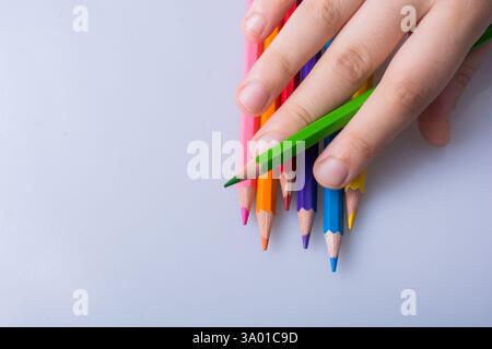 Hand holding color Pencils placed on a white background Stock Photo - Alamy