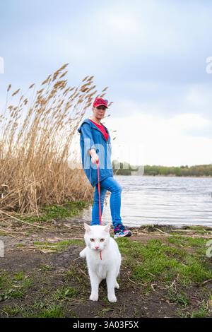 Girl walking with curious cat on her shoulder in the city park in ...